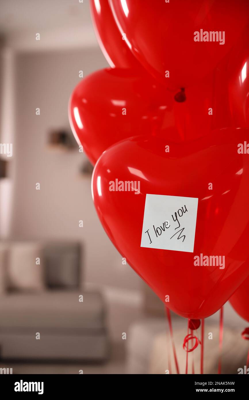 Red heart shaped air balloons with sticky note saying I Love You in ...