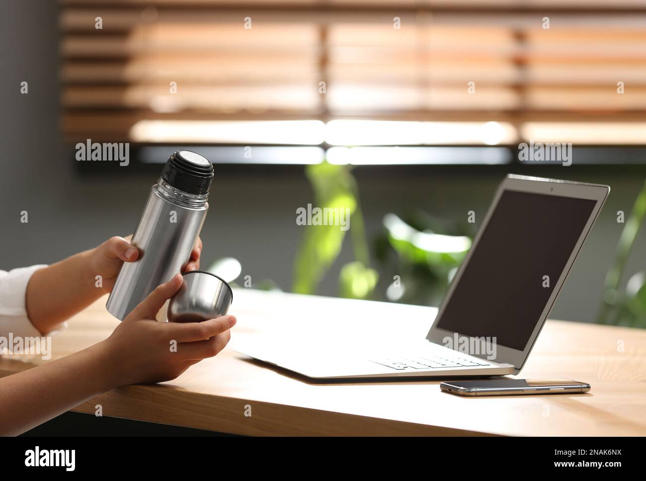Woman with modern thermos at workplace, closeup Stock Photo - Alamy