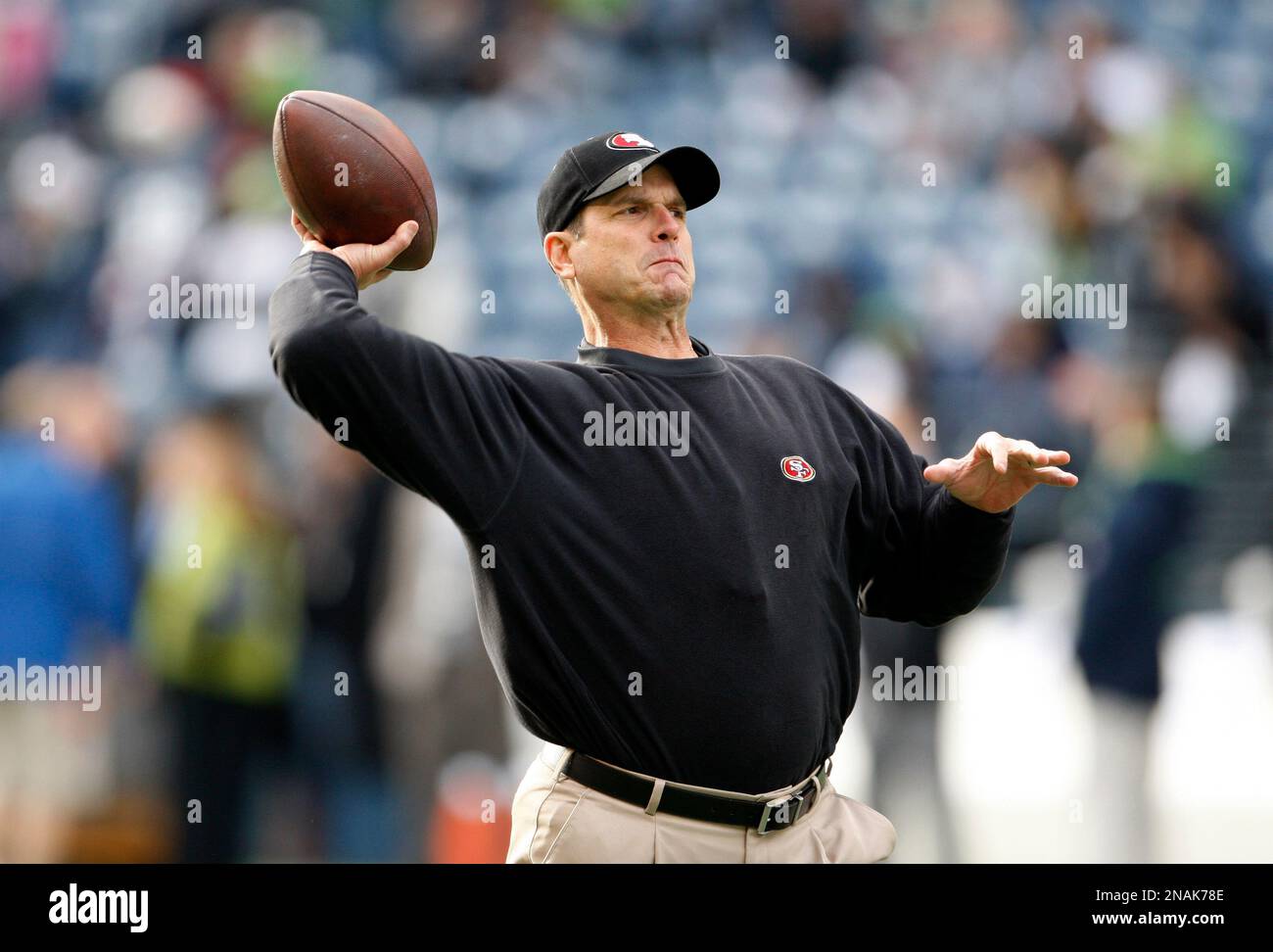 San Francisco 49ers head coach Jim Harbaugh throws a football before a ...