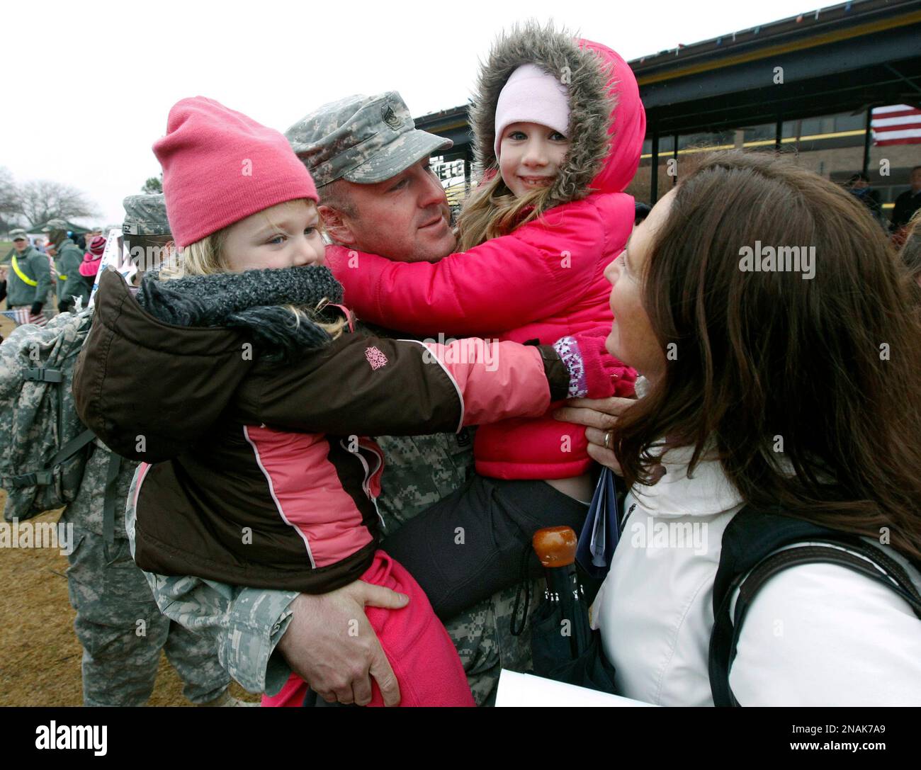 Sgt. Scott Dawson holds his daughters Mia, 5, left, and Victoria, 7 ...