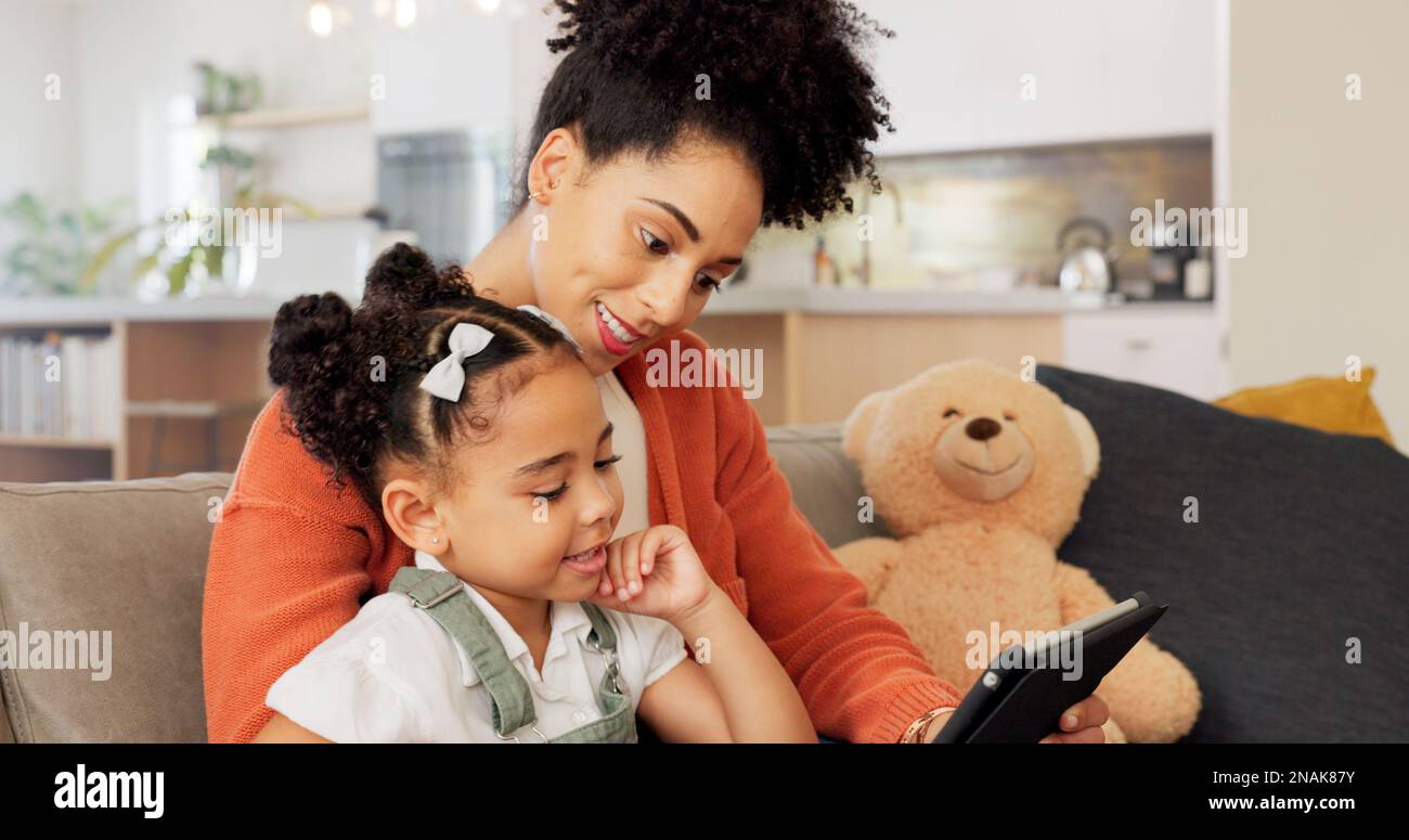 Mother, girl with tablet and learning on sofa at home for development ...