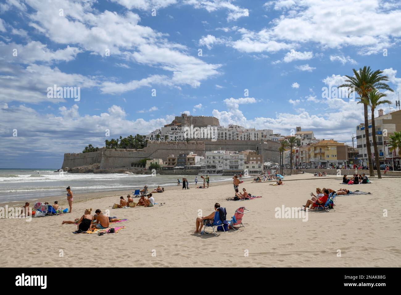 Tourists on the beach, in the background the old town with the ...
