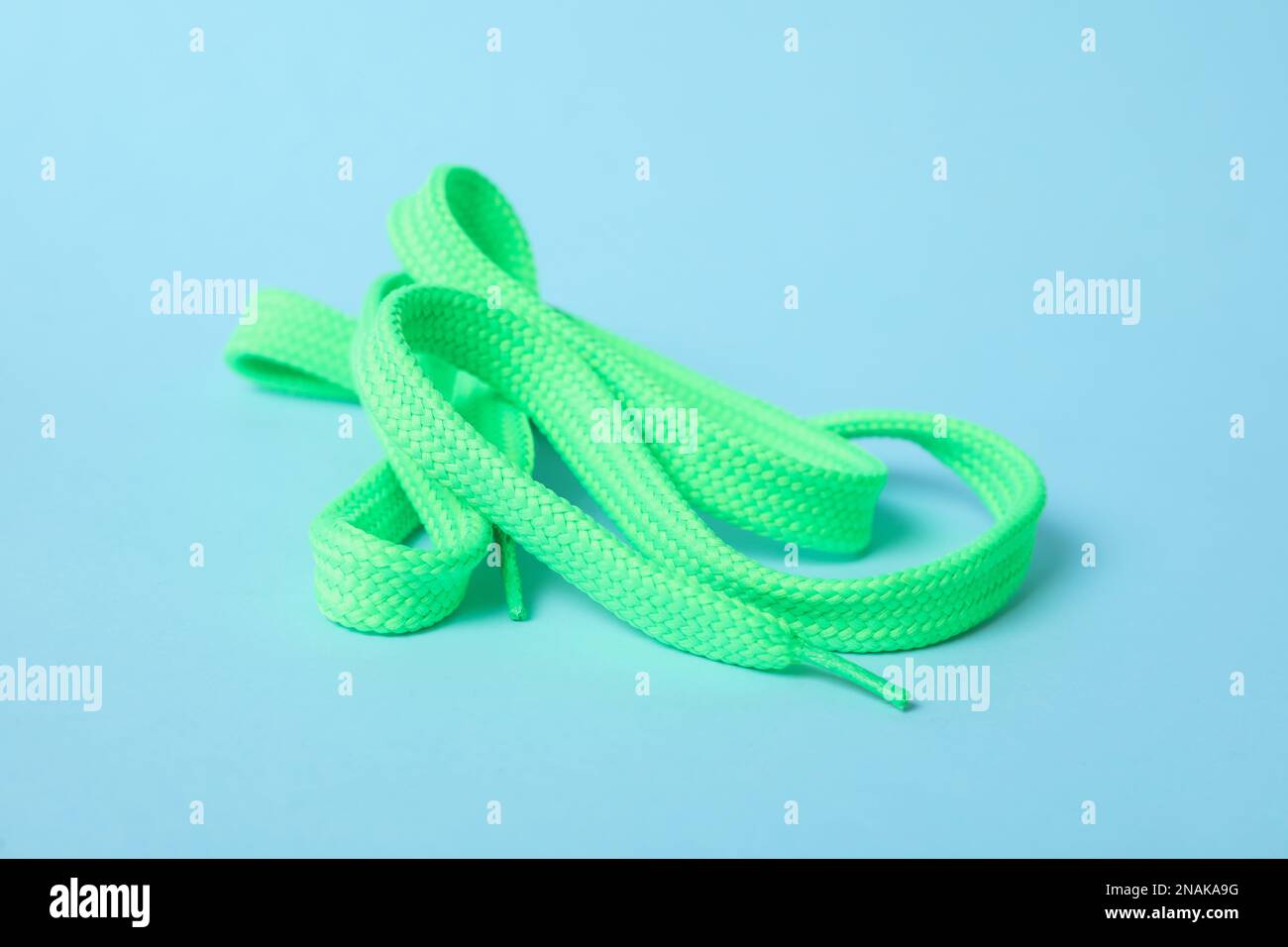 Mint shoe lace on light blue background Stock Photo - Alamy