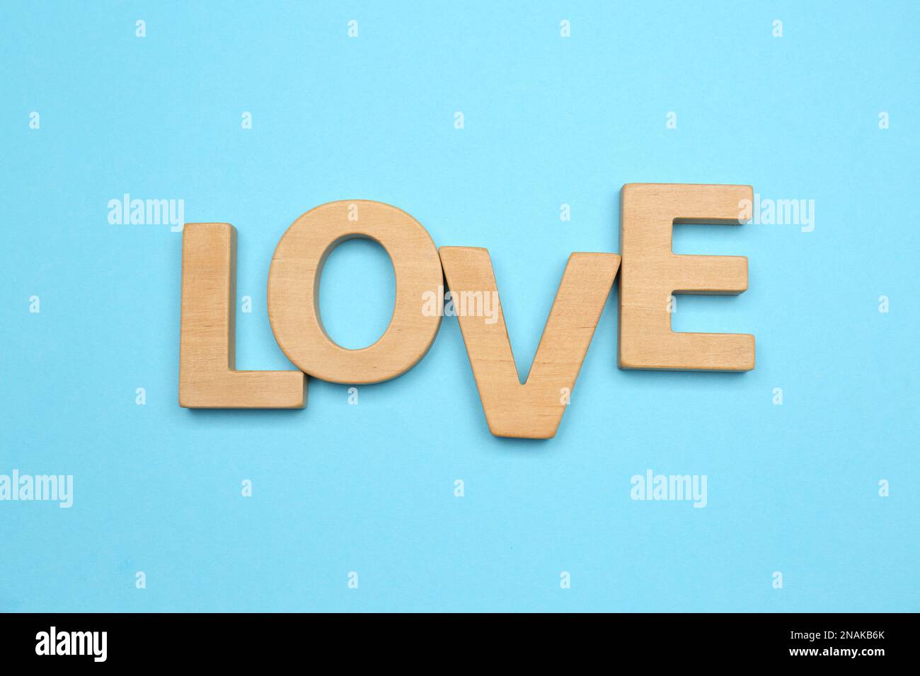 Word LOVE made of wooden letters on light blue background, flat lay ...