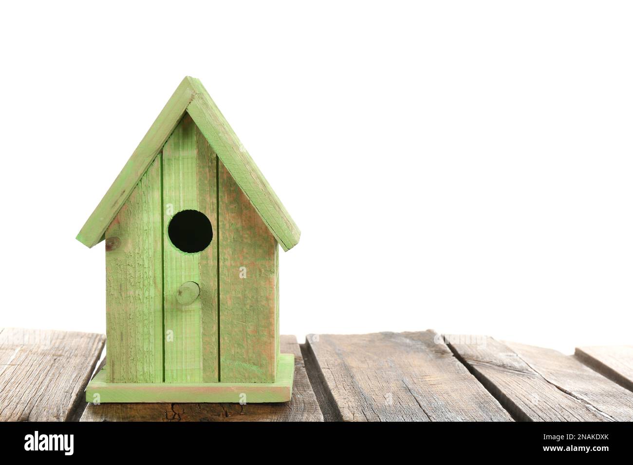 Beautiful green bird house on wooden table against white background ...