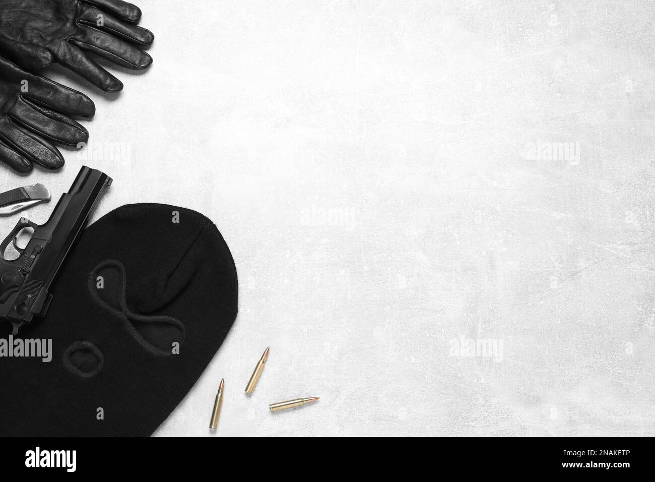Flat lay composition with balaclava and weapons on light table. Space ...