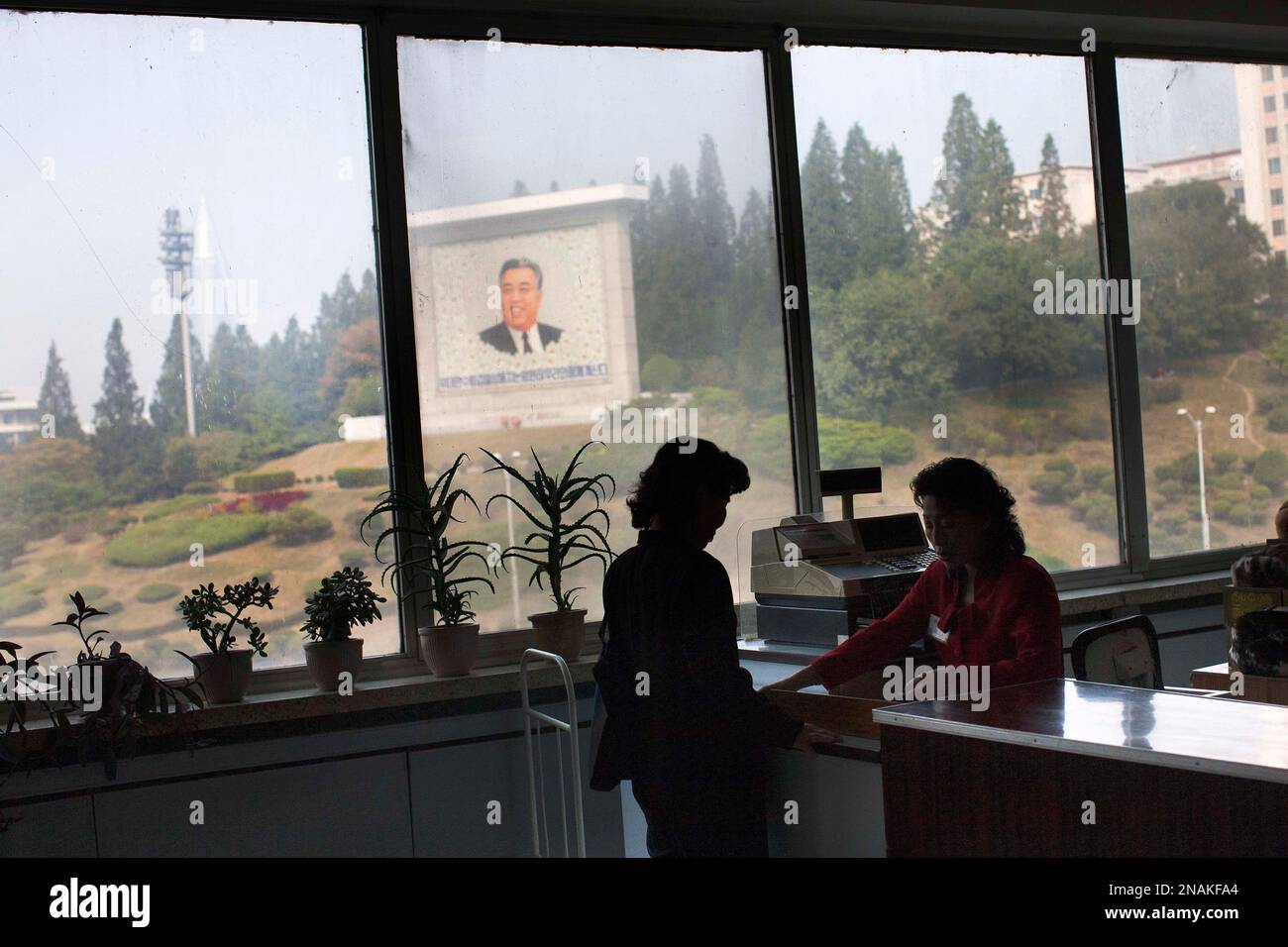 In this Sunday Oct. 9, 2011, a North Korean cashier helps a customer at ...
