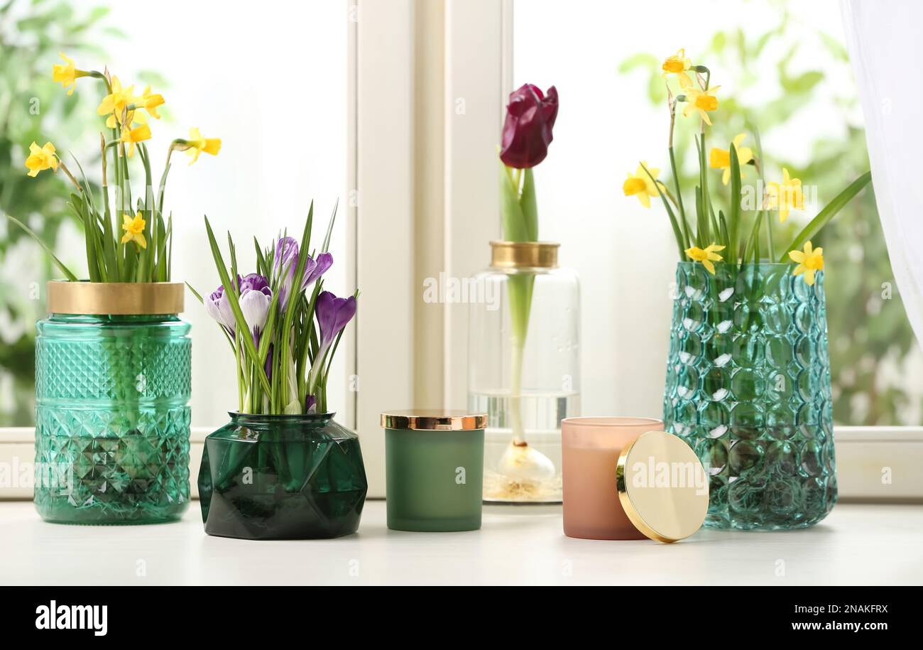 Different beautiful spring flowers and candles on window sill Stock ...