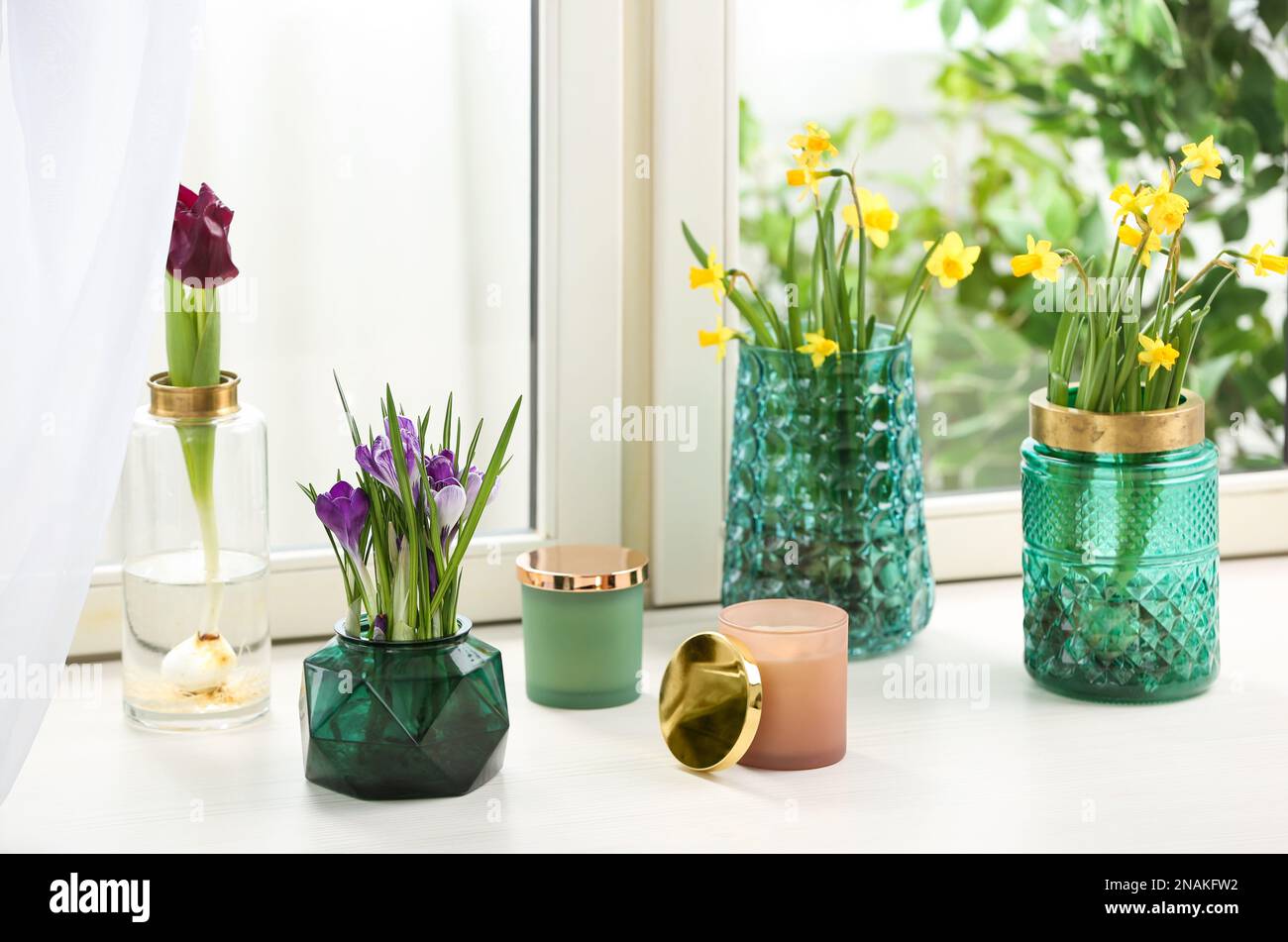 Different beautiful spring flowers and candles on window sill Stock ...