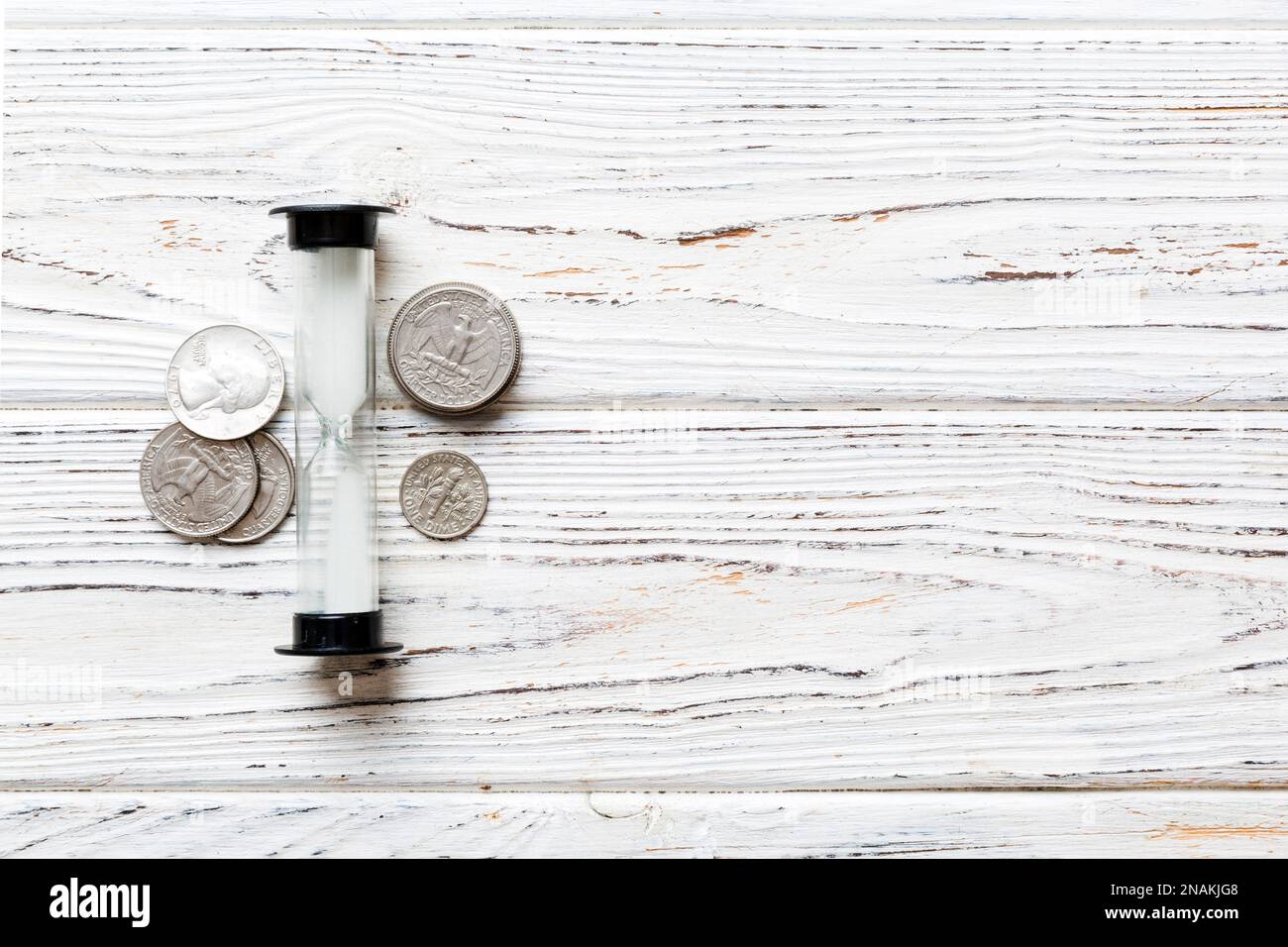 Deadline and time is money concept with hourglass and US coins currency ...