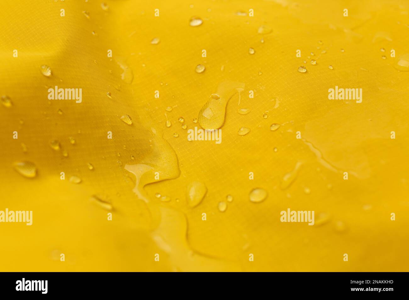 Yellow waterproof fabric with water drops as background, closeup Stock ...