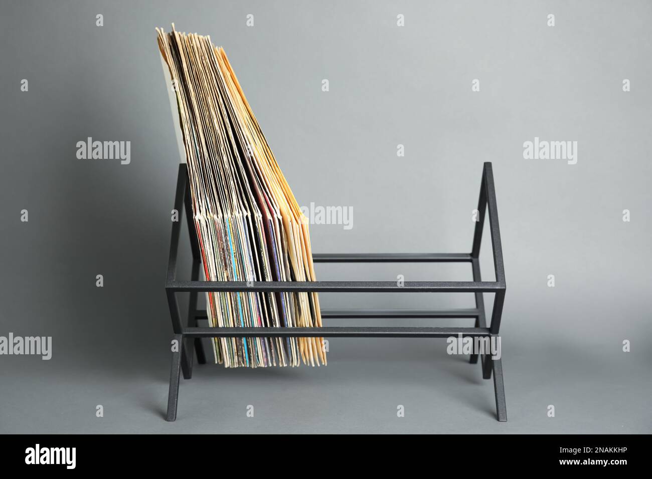 Rack with vinyl records in sleeves on grey background Stock Photo - Alamy