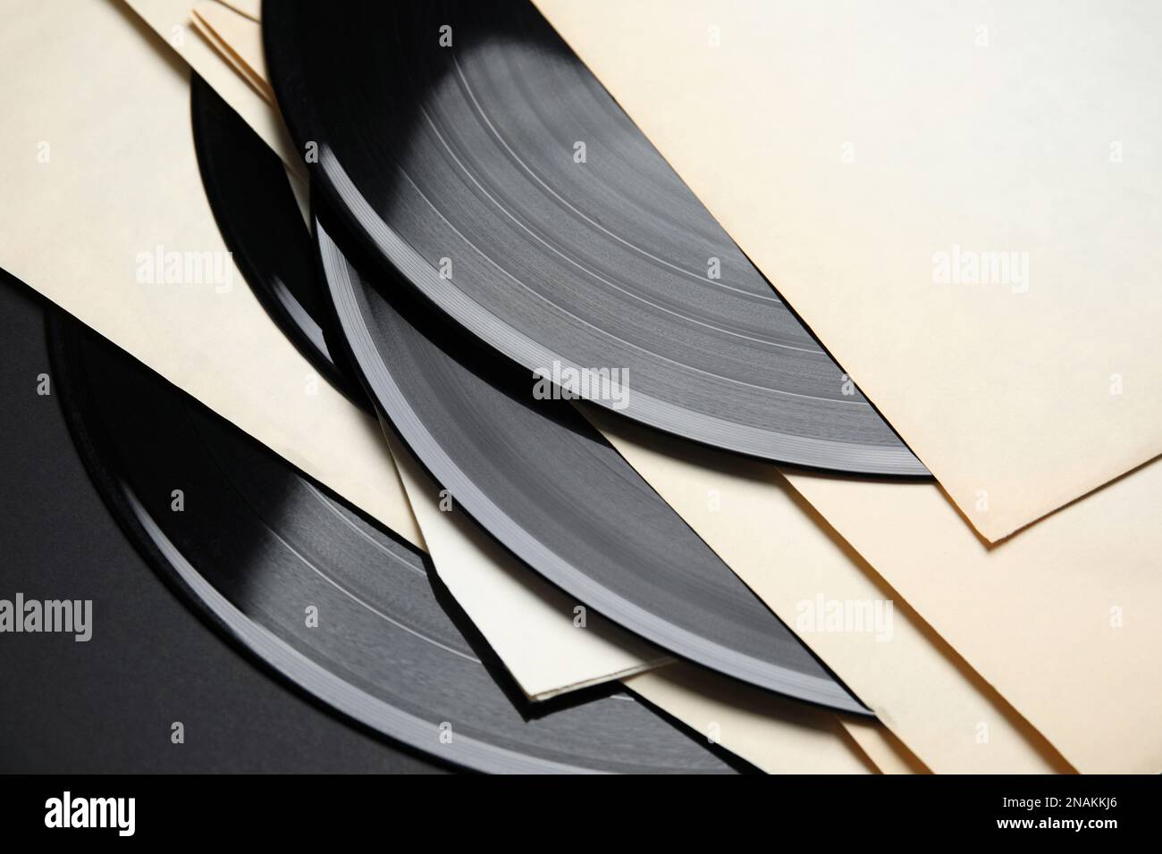 Vintage vinyl records in paper sleeves on black background, closeup ...