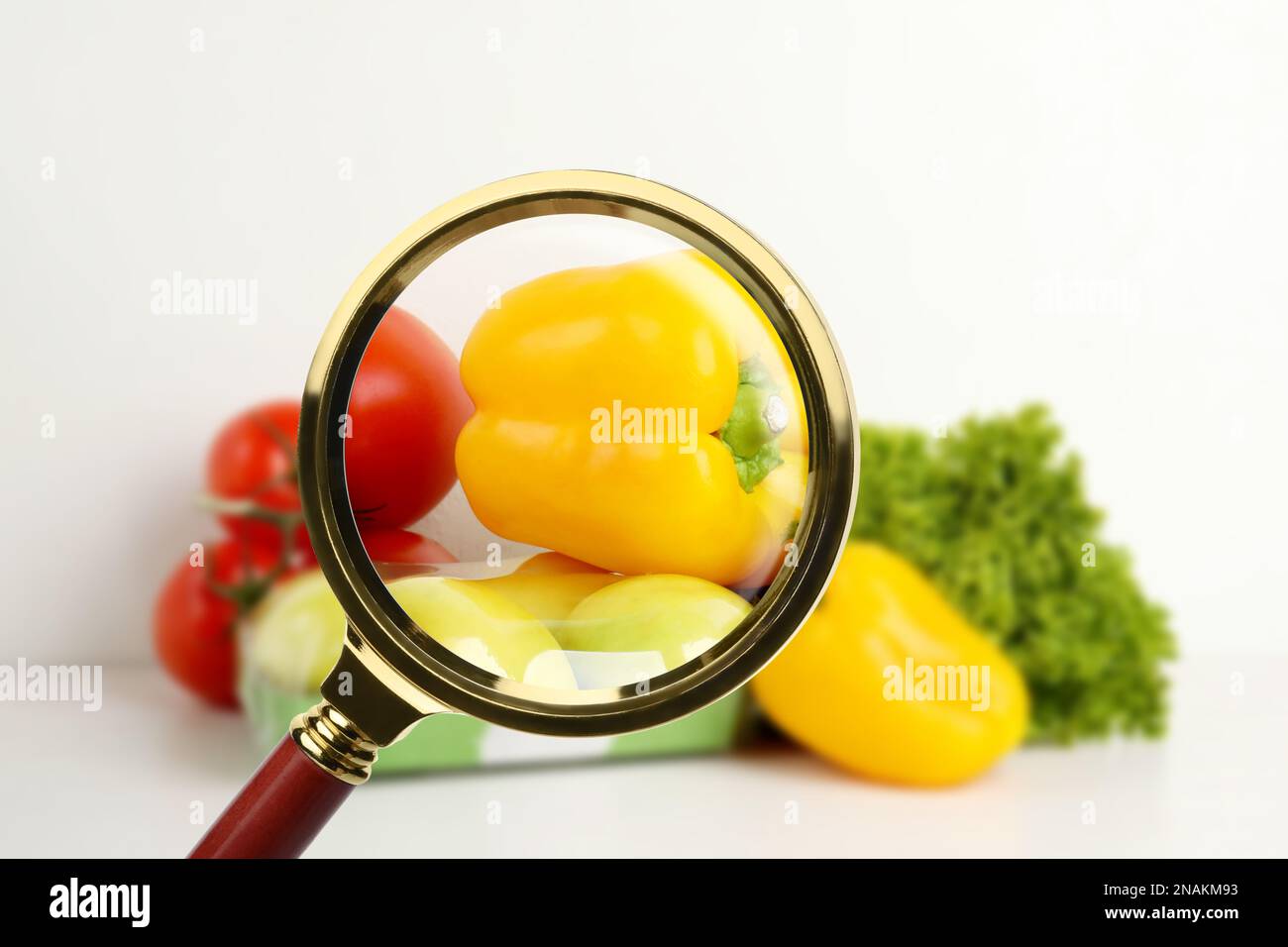 View through magnifying glass on vegetables, closeup. Poison detection ...