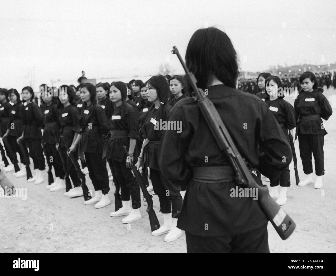 Graduates stand in formation with unloaded carbines during commencement ...