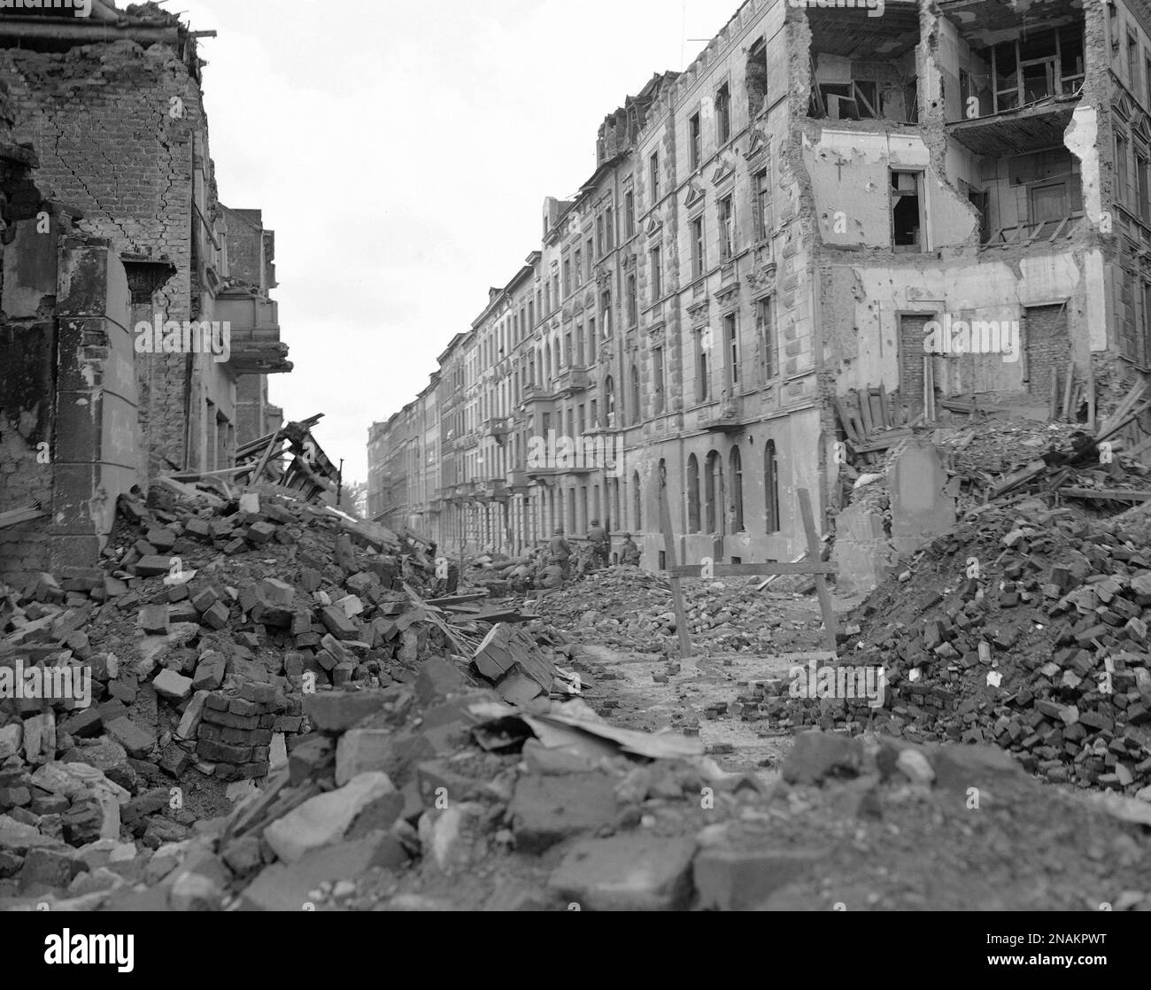 American troops, center, make their way through a damaged street in ...