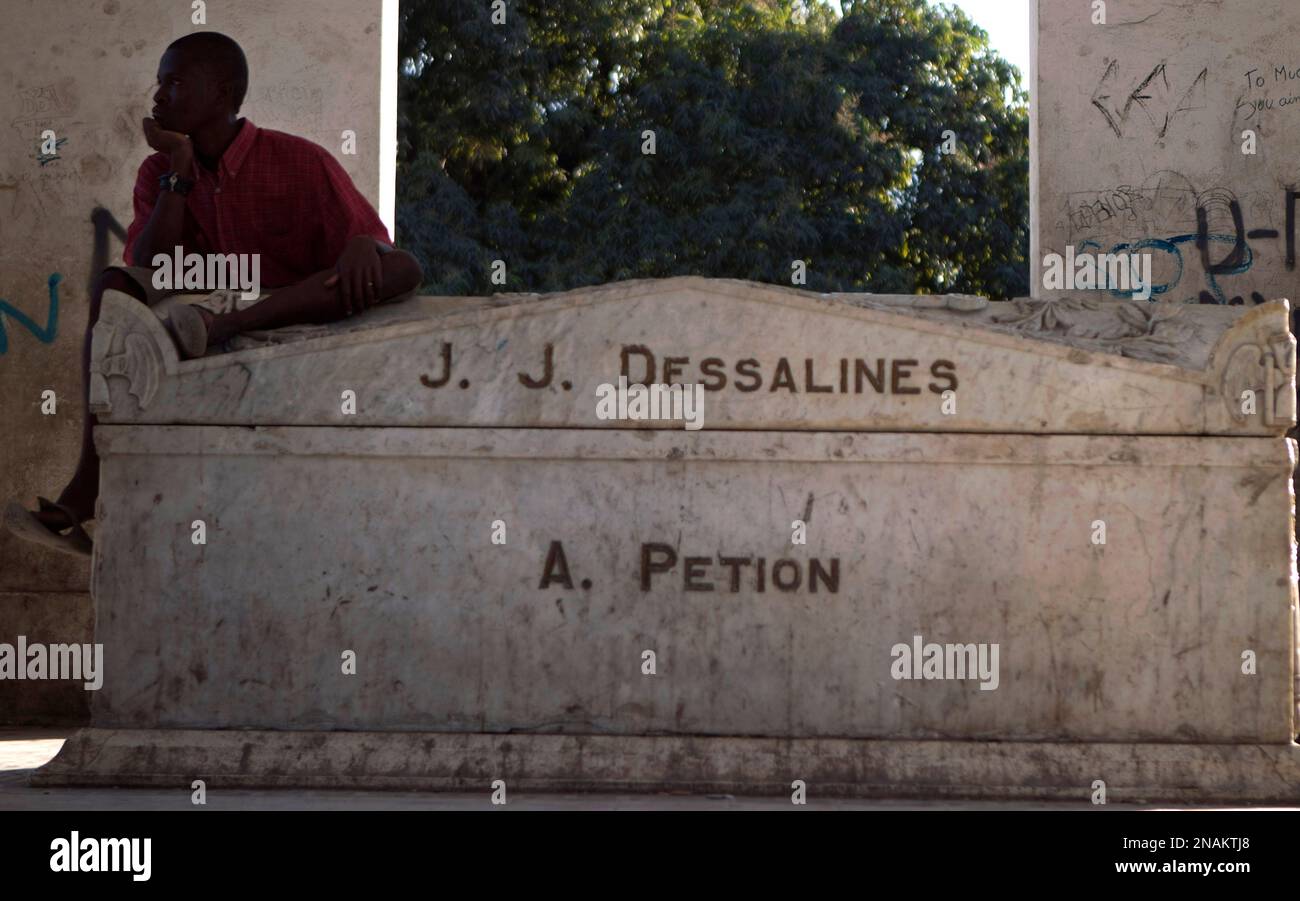A young man sits on the grave of Haiti's independence heroes Alexandre ...