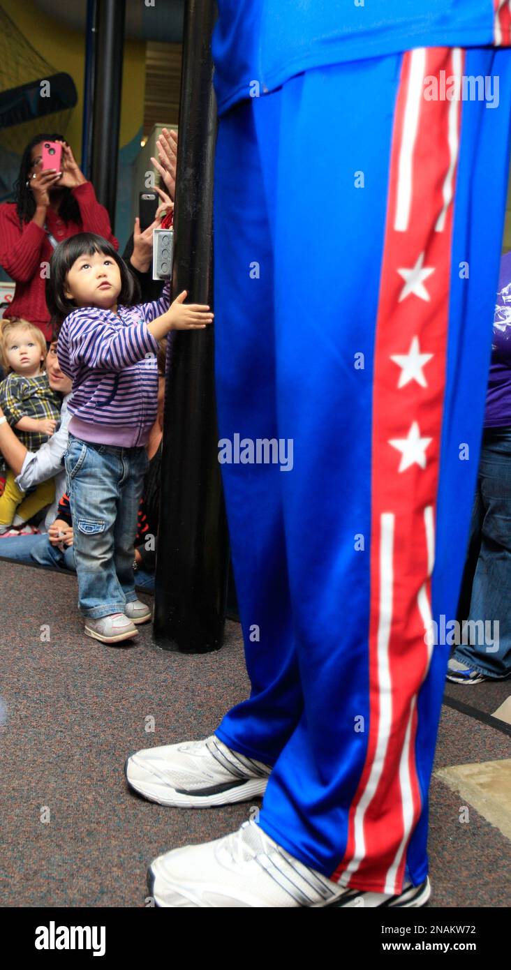 Cindy Jao, 2, looks up at Harlem Globetrotters' Paul "Tiny" Sturgess at ...