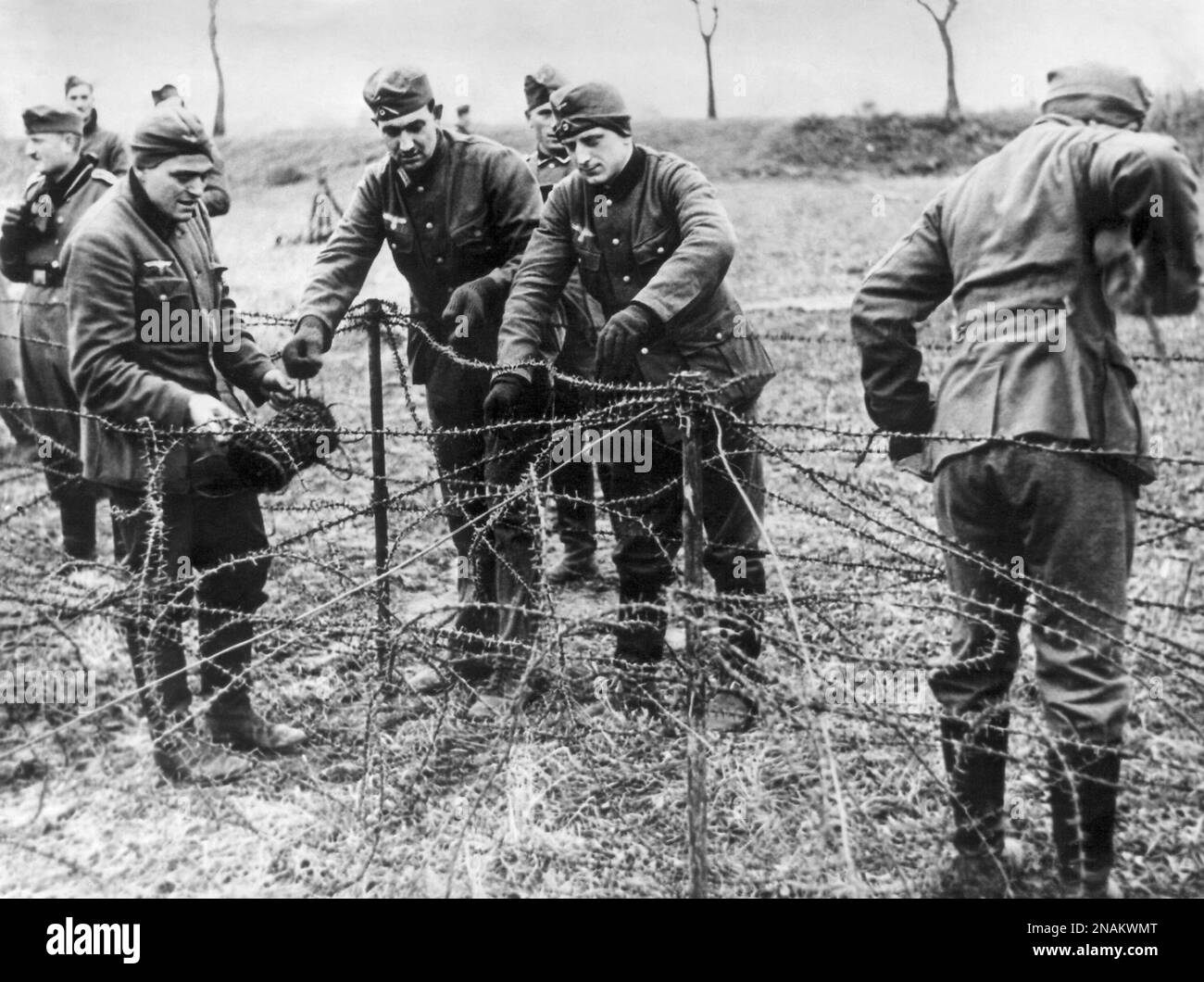 German pioneers working hard on a barbed wire obstacle in the line ...