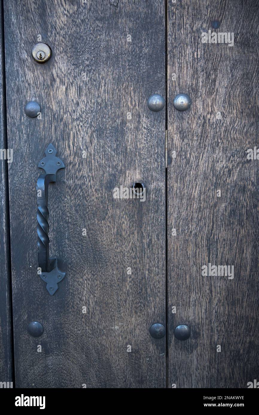 Old and modern lock on old dark door with iron handle in vertical Stock ...