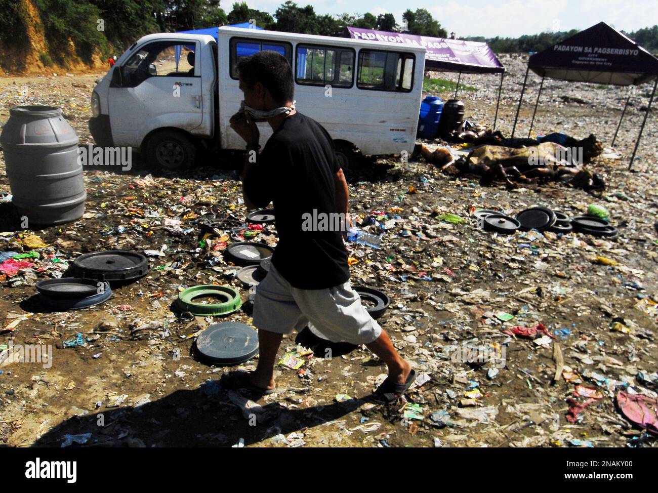 EDS NOTE: GRAPHIC CONTENT - A resident covers his nose as he passes by ...