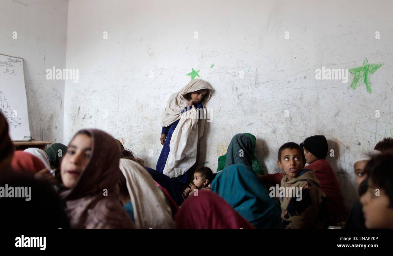 An Afghan refugee child, bottom center, sits with his sister while ...