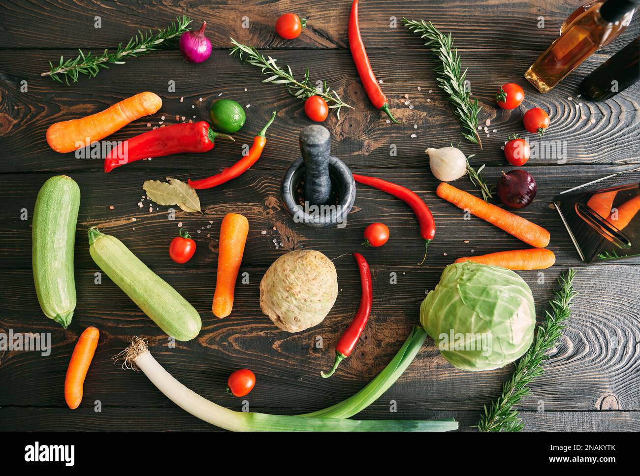 Top view of various fresh raw vegetables and herbs on dark wooden table ...