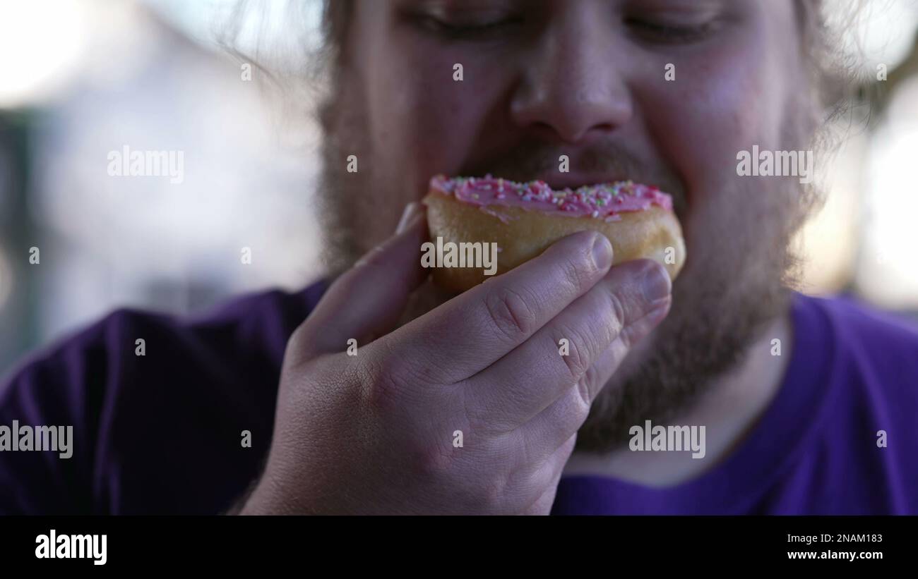 One fat man eating donut snack. Overweight person eats junk food. Guy ...