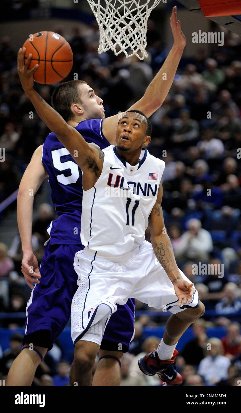 Connecticut's Ryan Boatright (11) scores in front of Holy Cross' Dave ...