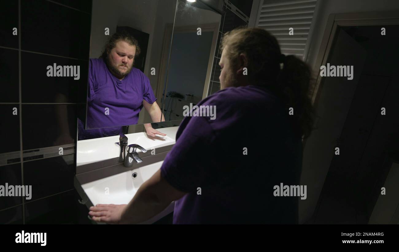 Confused sad man leaning on bathroom sink in dilemma and doubt. Person ...
