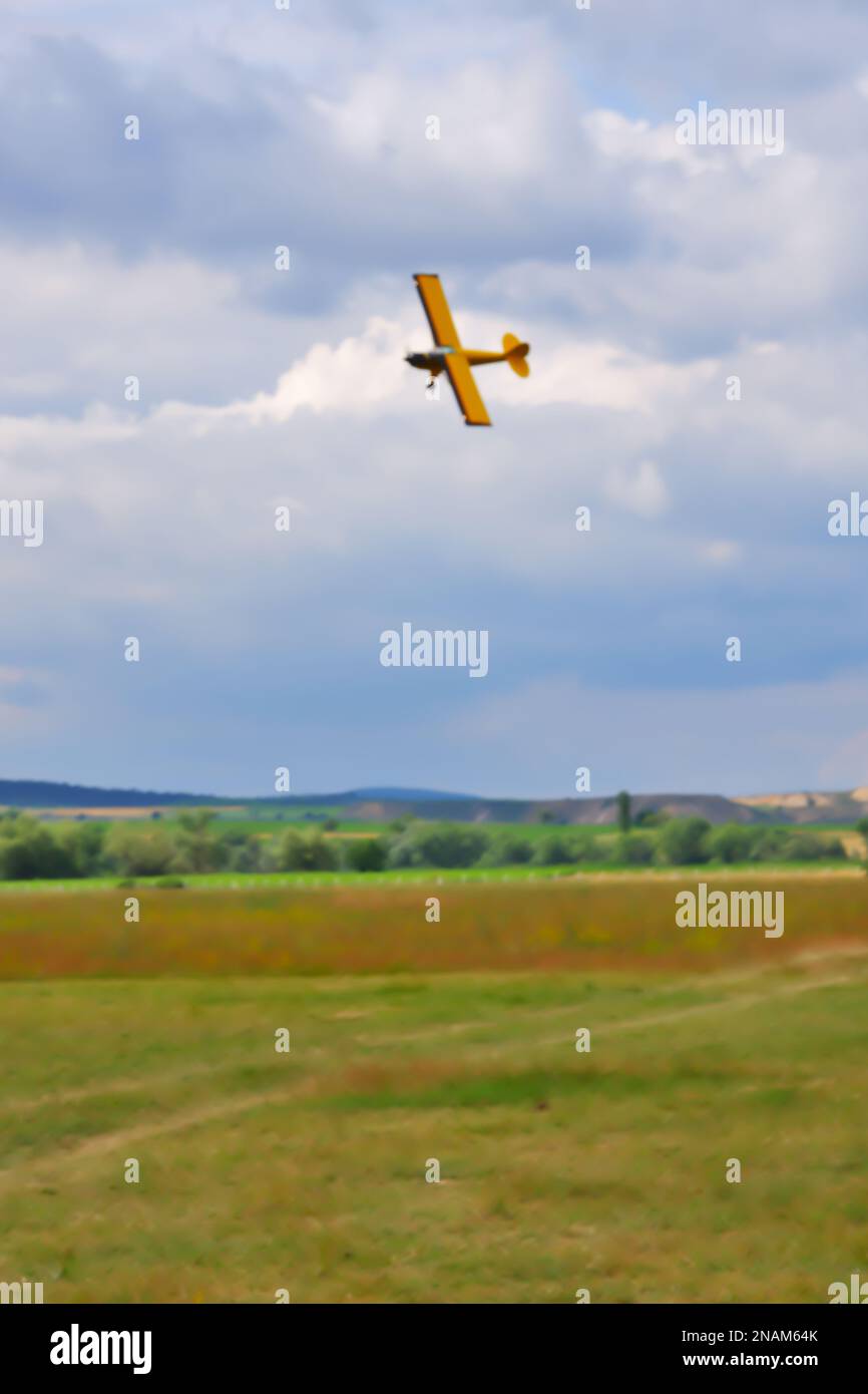 Yellow single engine airplane maneuvering close to the ground with ...