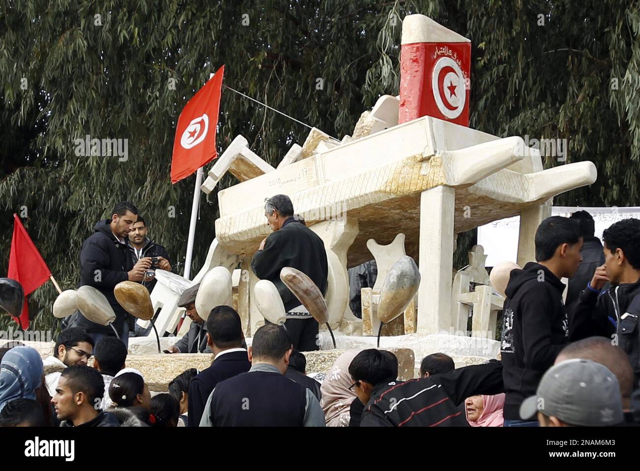 People walk past a statue depicting Mohamed Bouazizi, a 26-year-old who ...