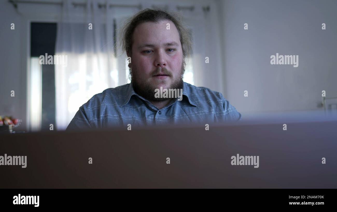 One male entrepreneur in front of computer working from home. A chubby ...