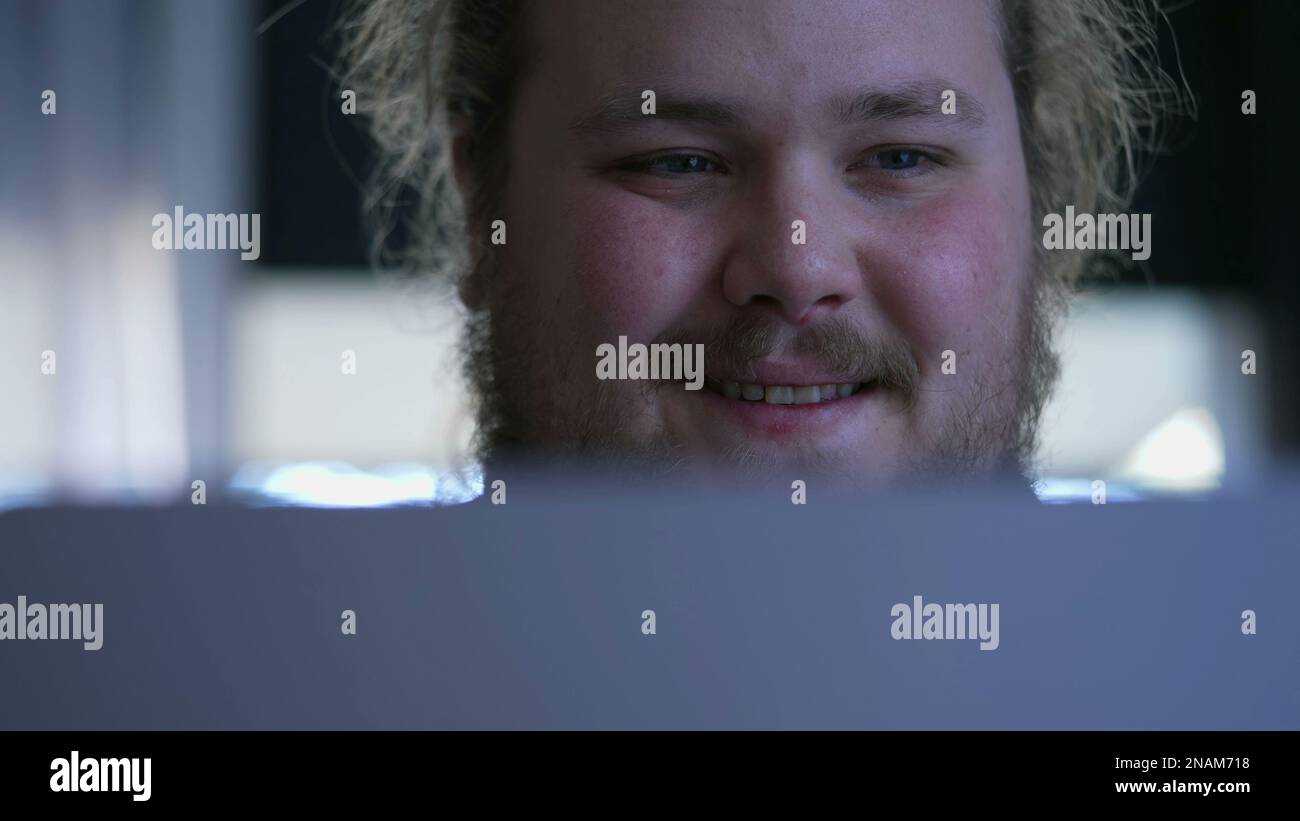 One happy man in front of computer screen browsing internet . Close up ...