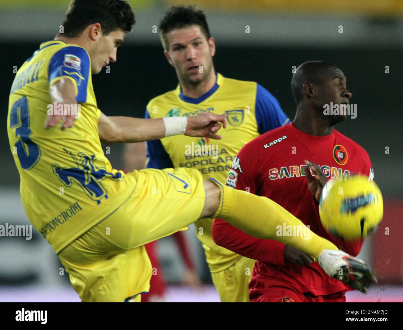Chievo's Marco Andreolli, left, kicks the ball in front of Cagliari's ...