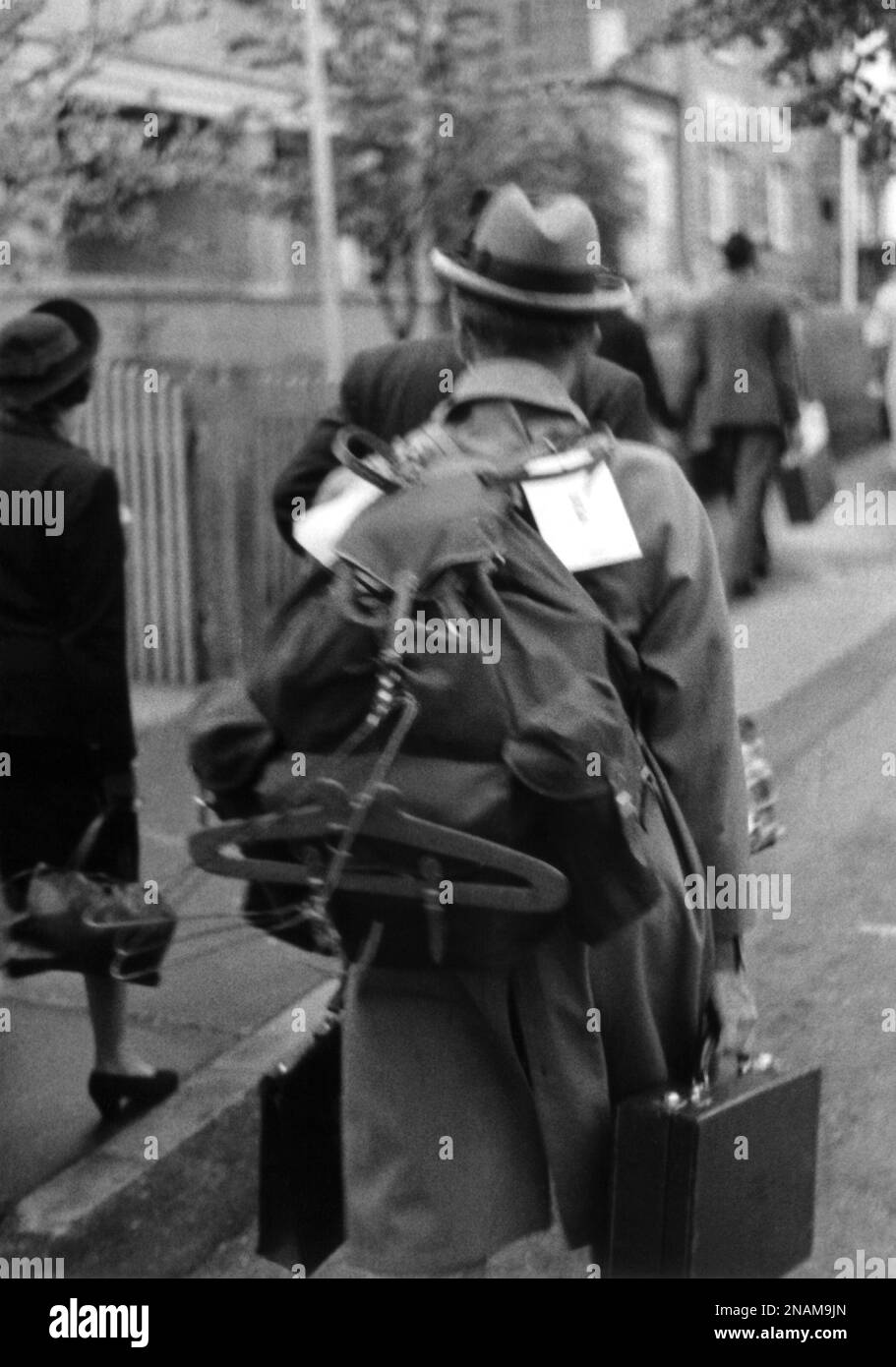 Vice-consul Francis Cunningham carries a load as he leaves internment ...