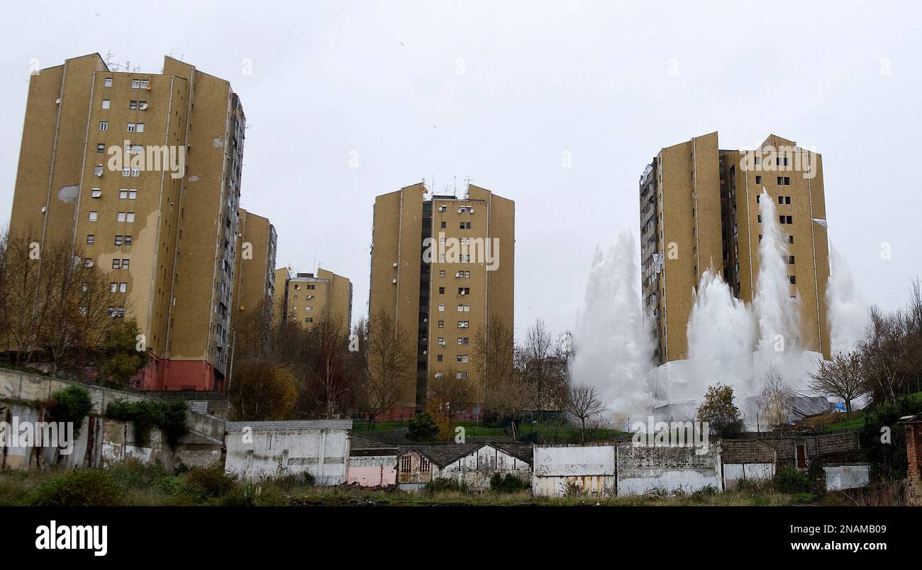 A building collapses in a cloud of dust and water while being imploded ...