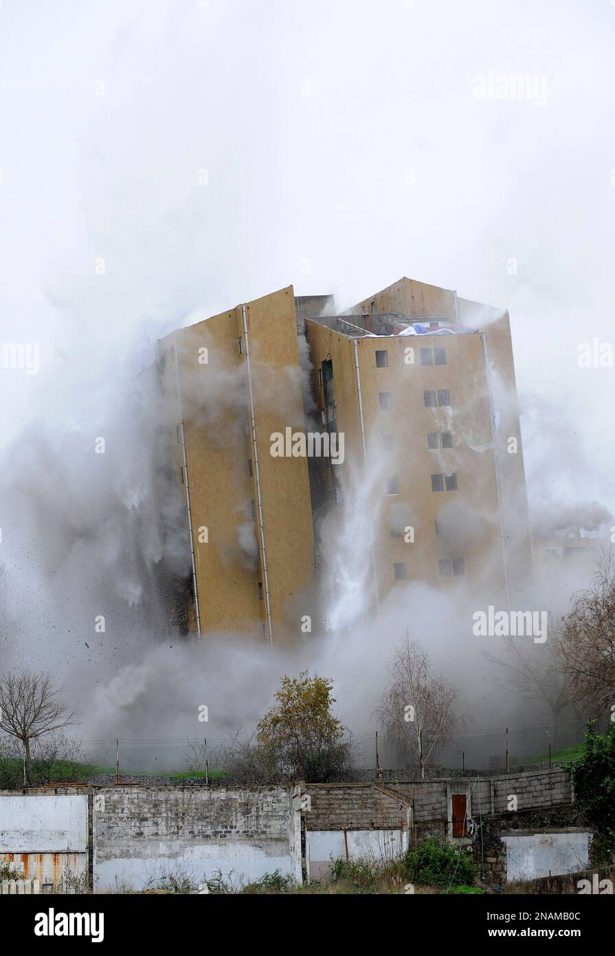 A building collapses in a cloud of dust and water while being imploded ...