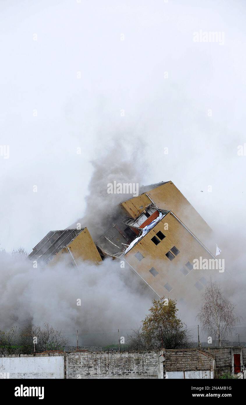 A building collapses in a cloud of dust and water while being imploded ...
