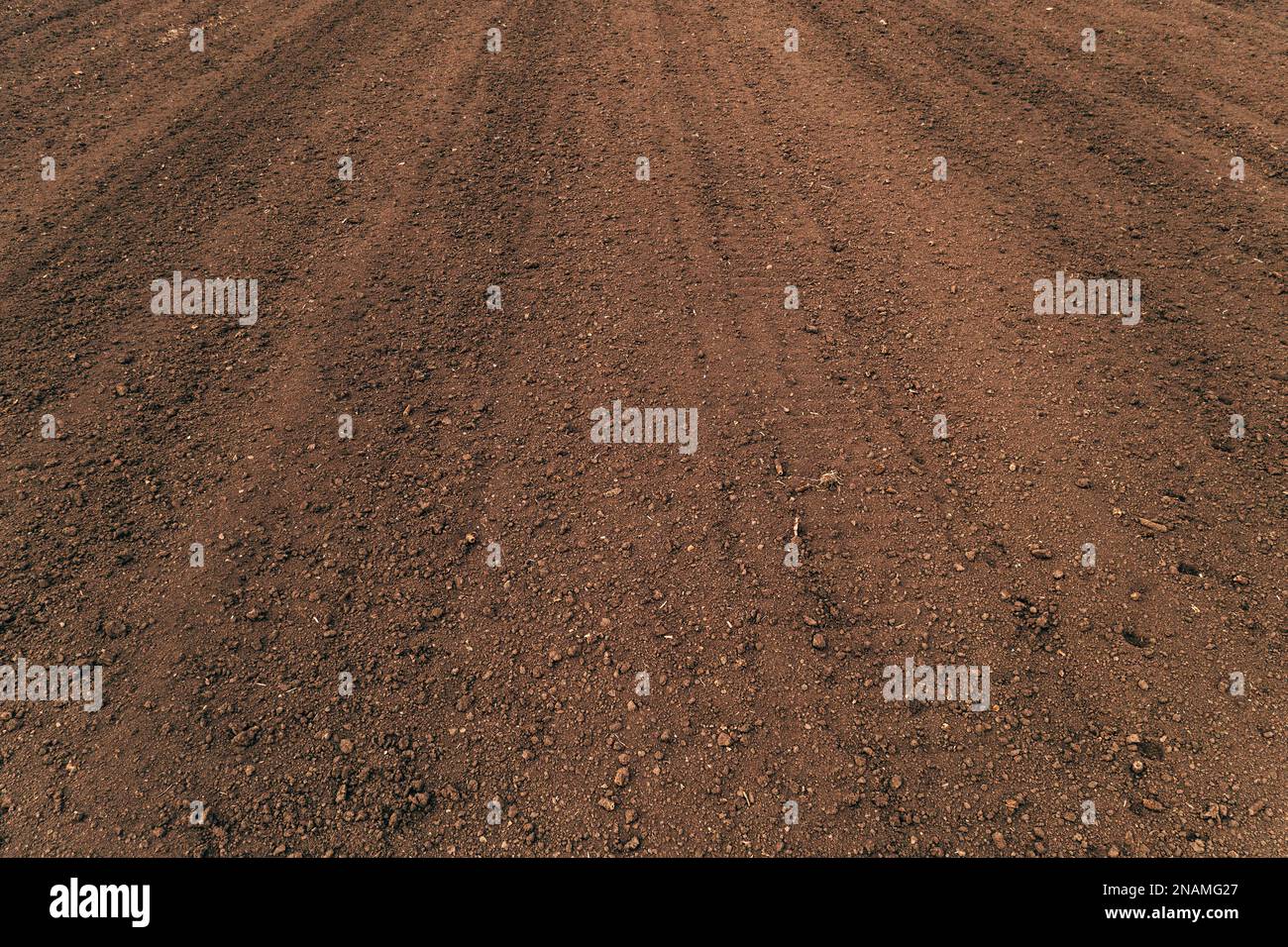 Ploughed soil in perspective as background, aerial view from drone pov ...