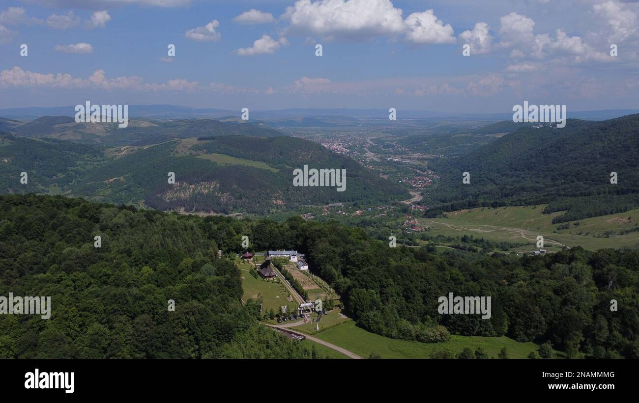 A drone shot of the rural area in Romania surrounded by rich vegetation ...