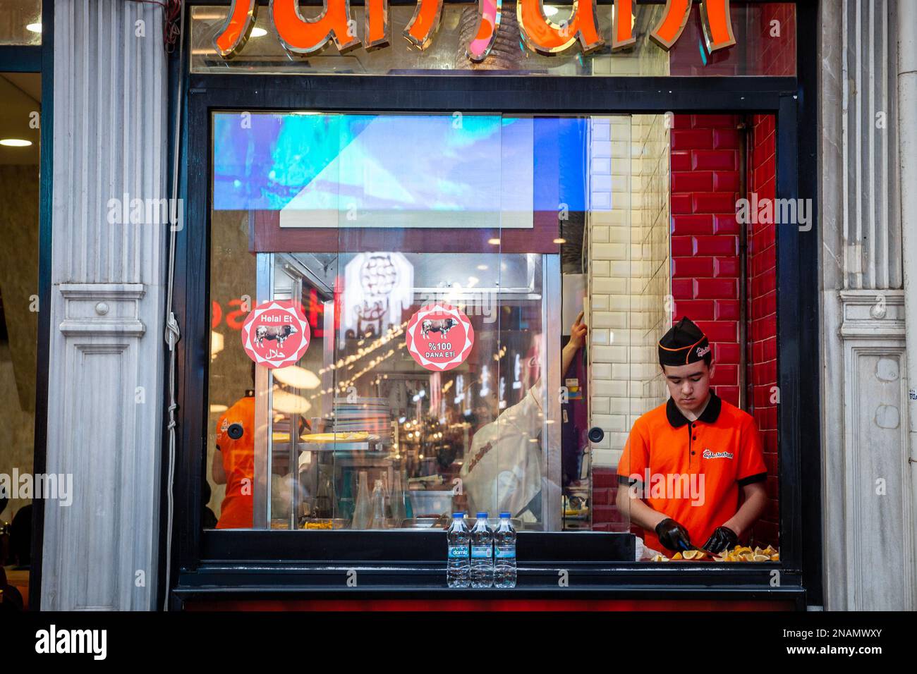 Picture of a man, a young apprentice, a kebab master, preparing to cut ...