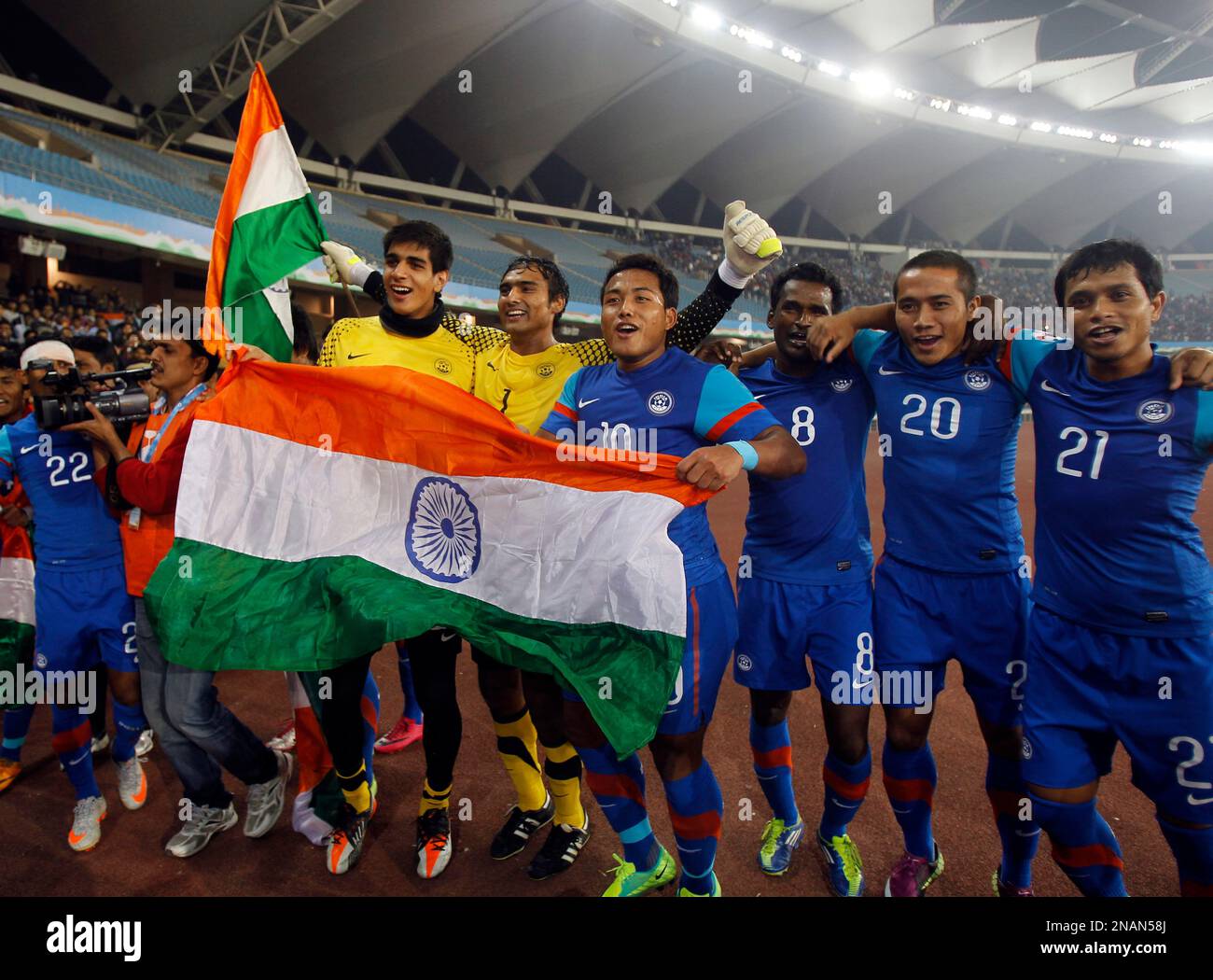 Indian team members celebrate with the Indian flag after winning the ...