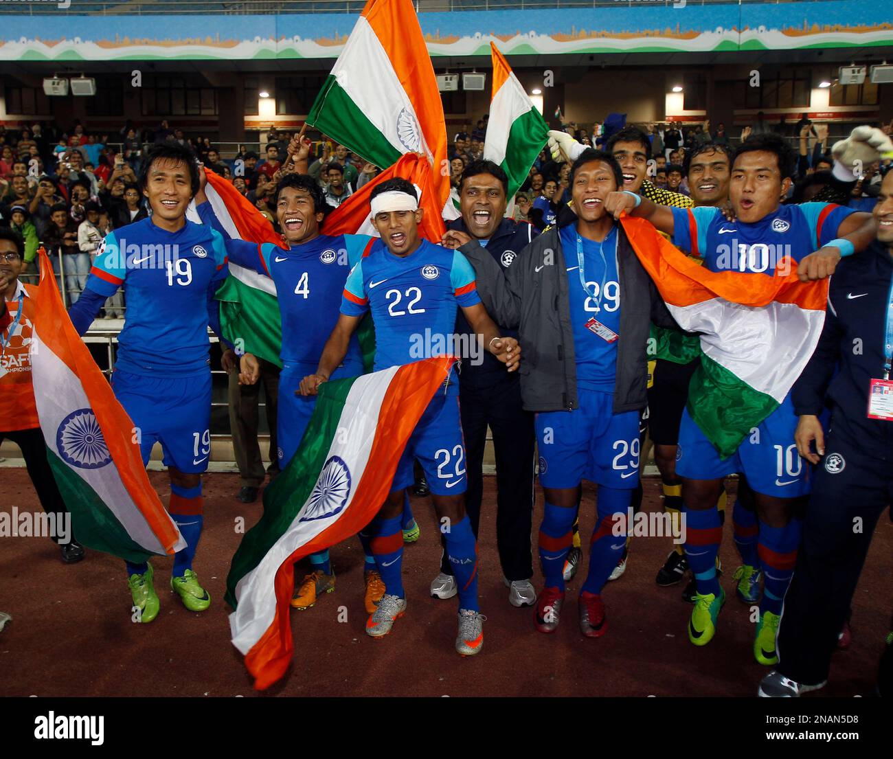 Indian team members celebrate with the Indian flag after winning the ...