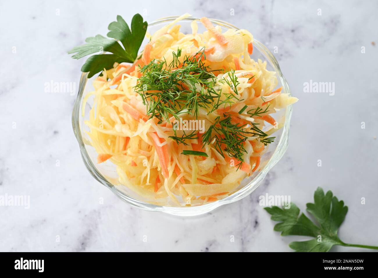 Homemade sauerkraut with carrots, dill in a plate on a light background ...