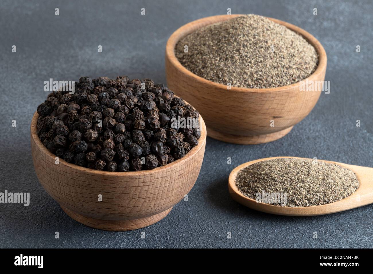 Ground black pepper with grains of black pepper on black background ...