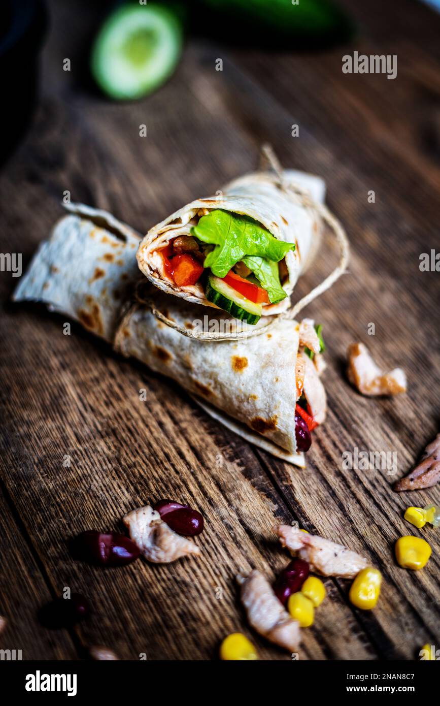 Traditional mexican tortilla wrap with chicken meat and vegetables on ...
