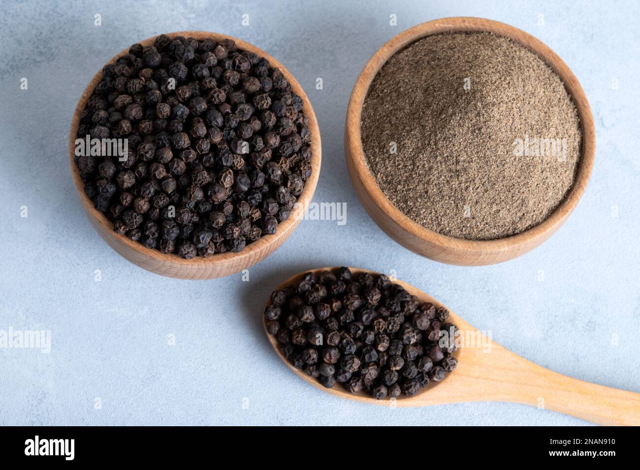 Ground black pepper with grains of black pepper on a bright background ...