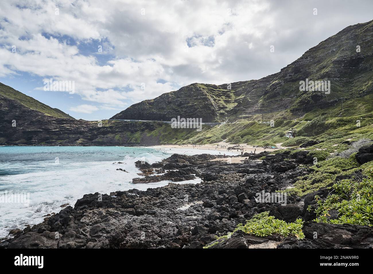 Overview of Makapu'u Beach with ocean and mountains and people in the ...