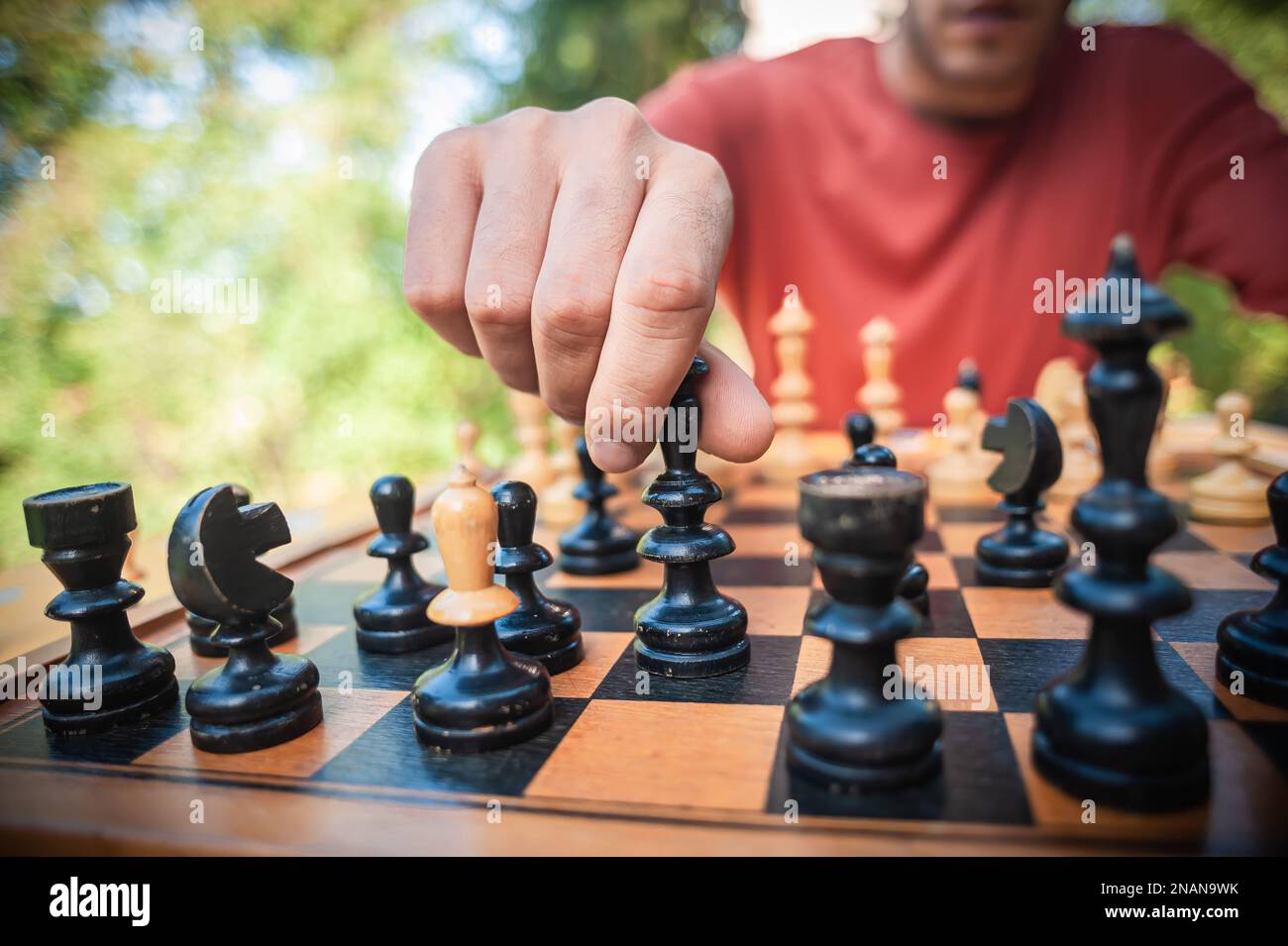 Hand of a man taking a chess piece to make the next move in a chess ...